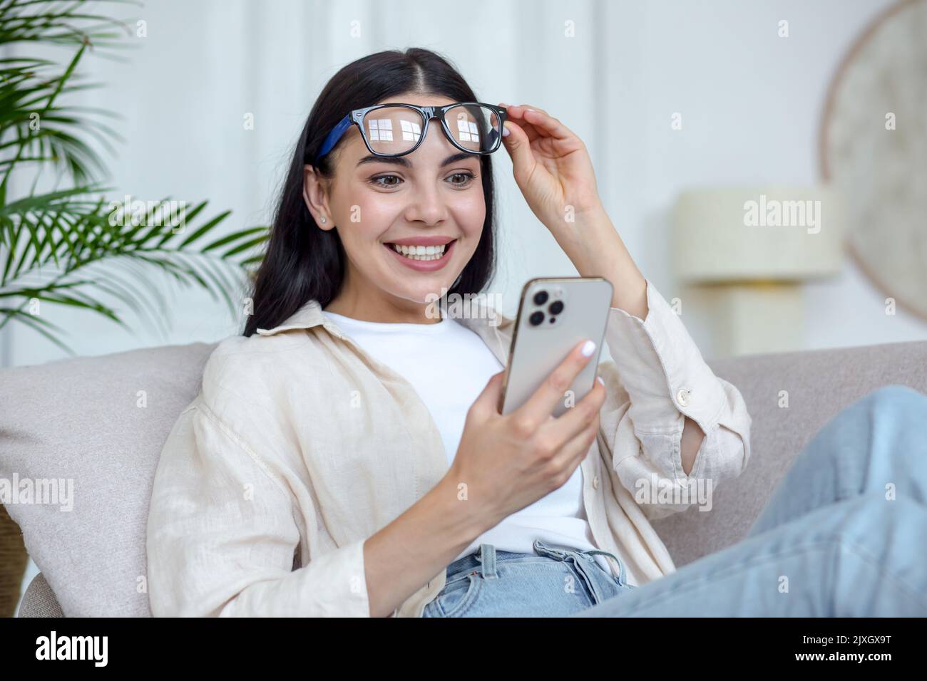 Woman sitting home holding hi-res stock photography and images - Alamy