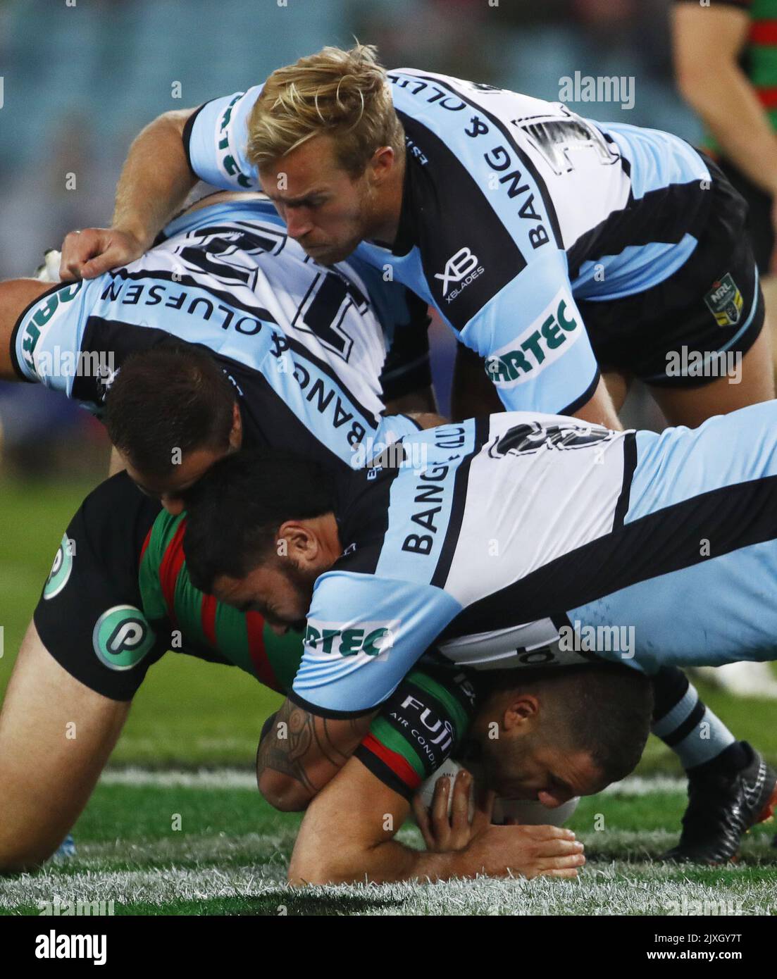 Robbie Farah of the Rabbitohs (below) is tackled by Sharks defence ...