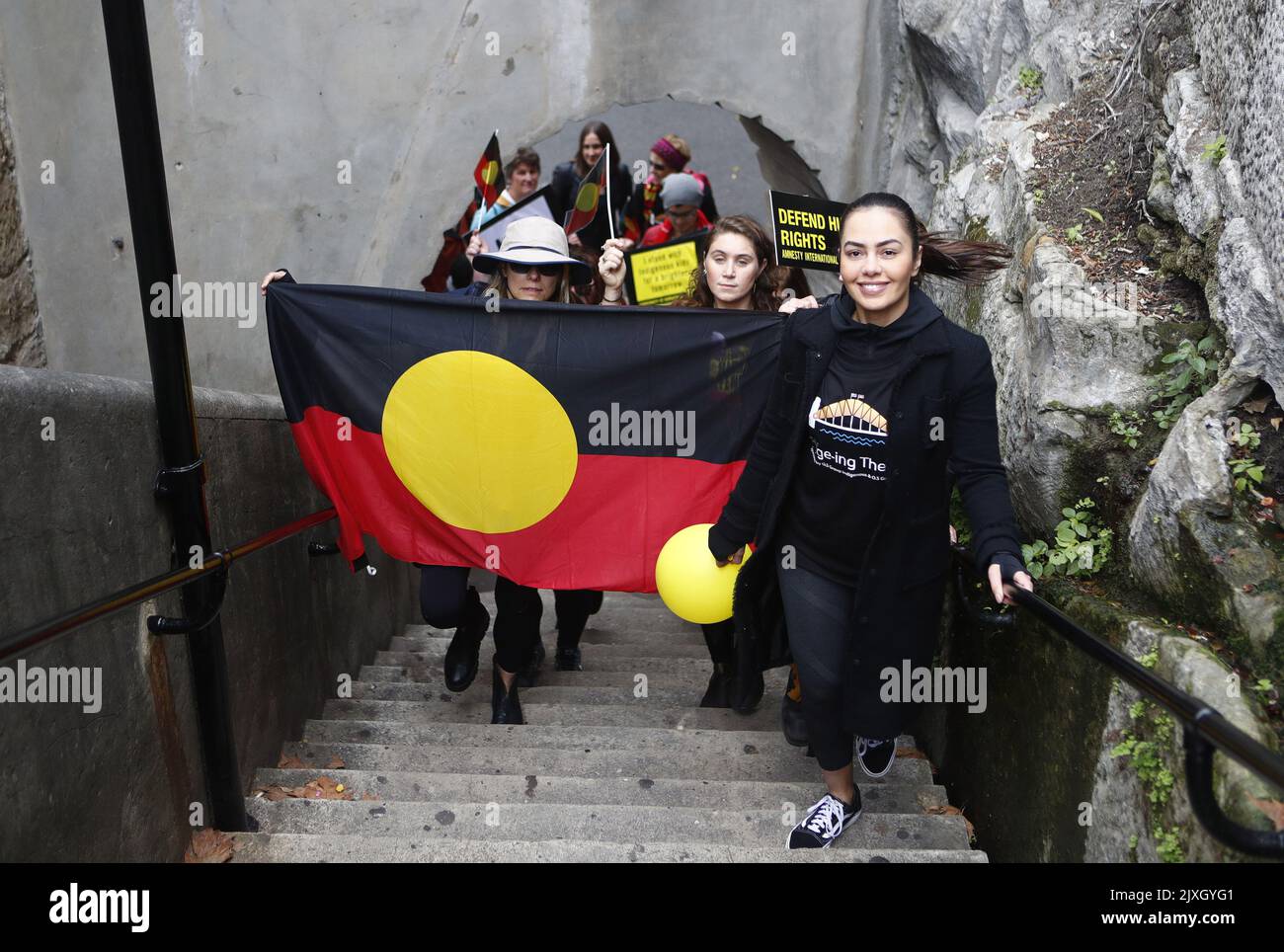 Cheree Toka and fellow demonstrators carry an Australian Aboriginal ...