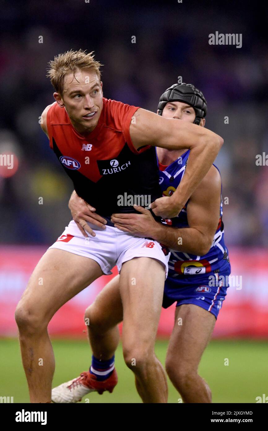 Bernie Vince of the Demons is tackled by Caleb Daniel of the Bulldogs ...