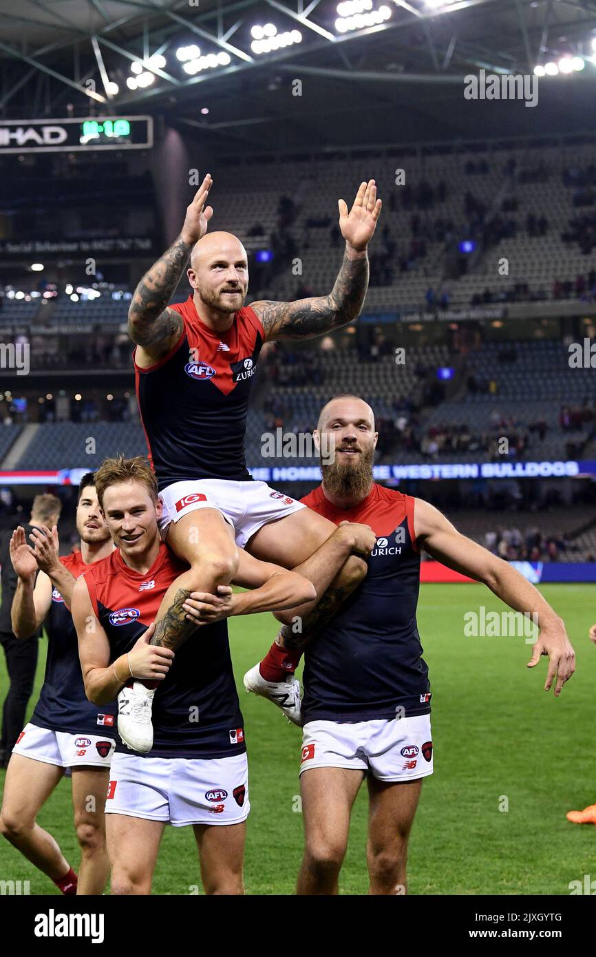Nathan Jones of the Demons is carried off the ground by team mates ...