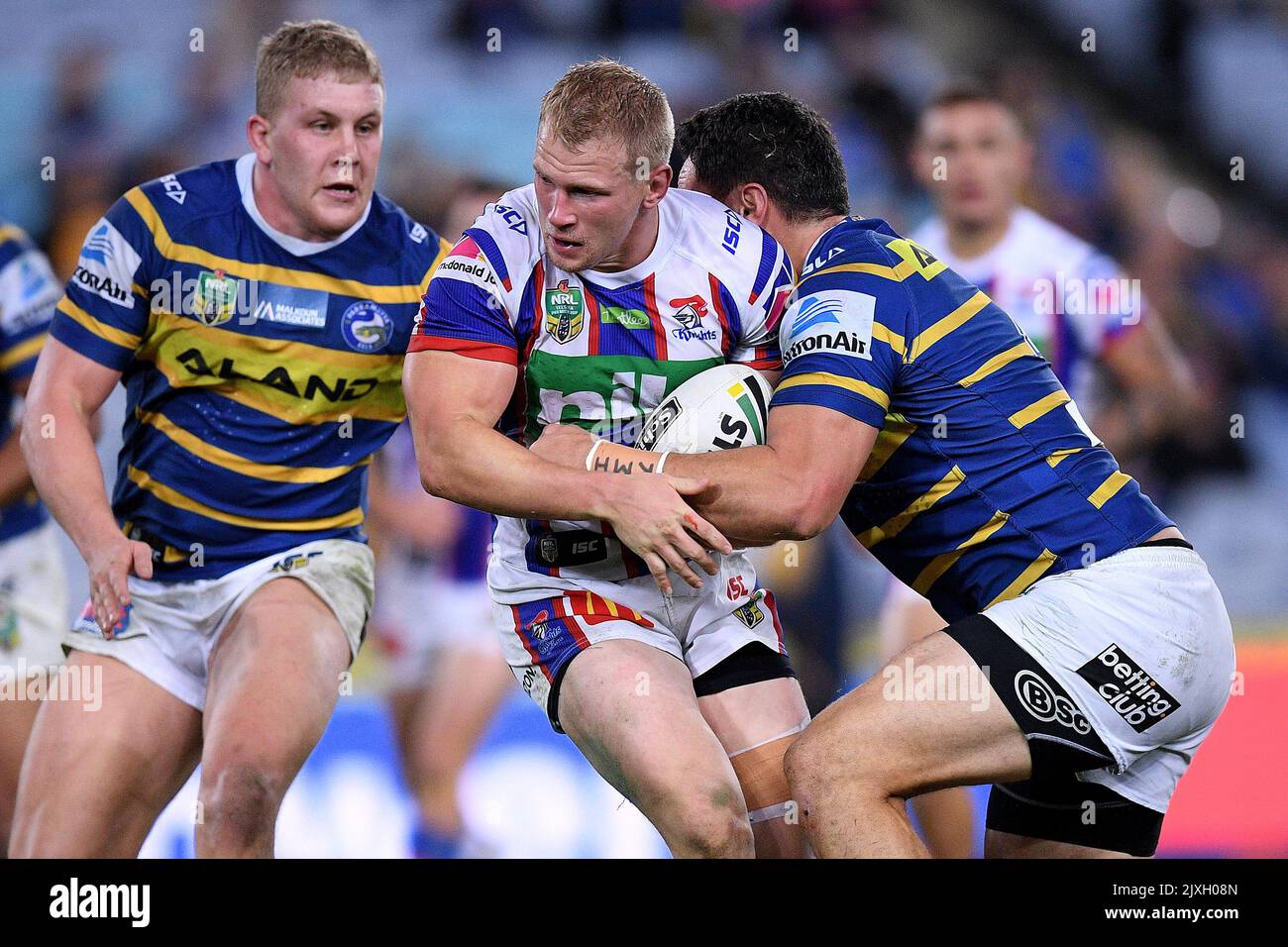 Slade Griffin of the Knights is tackled by Brad Takairangi of the Eels ...