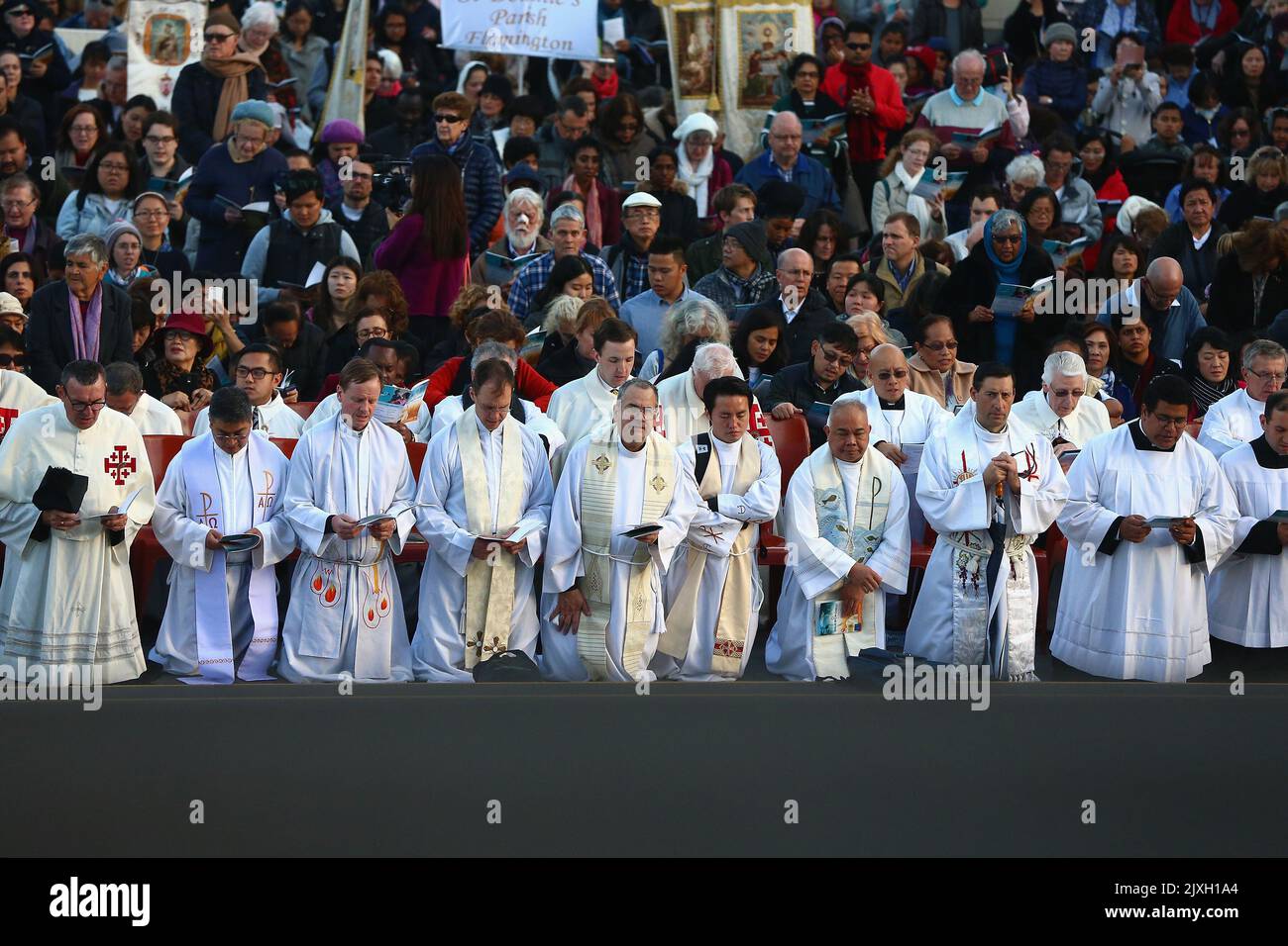 Priest and attendees pray during a Catholic March in Sydney on Sunday ...