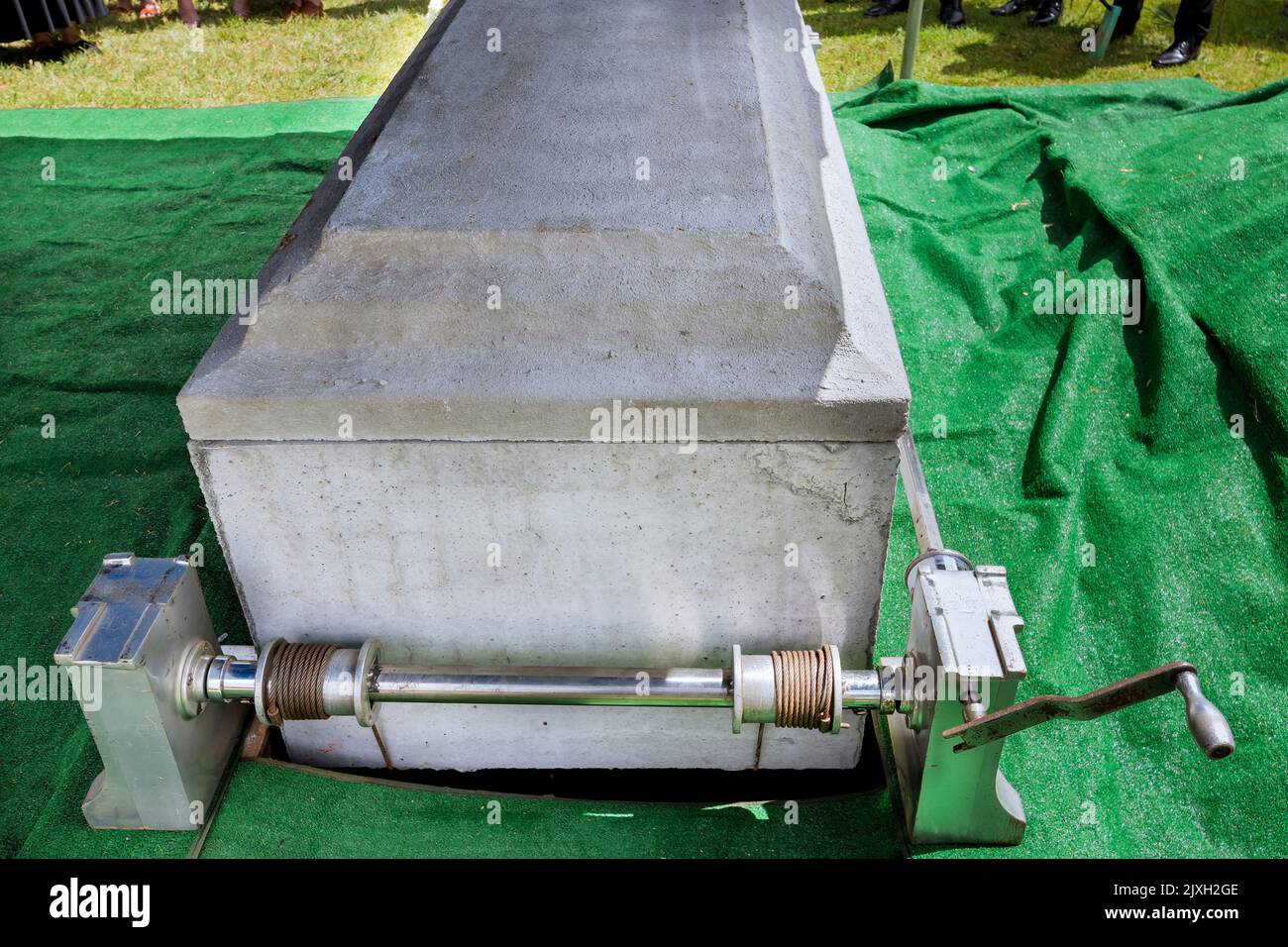 During a funeral service at a cemetery, the coffin is placed on an ...