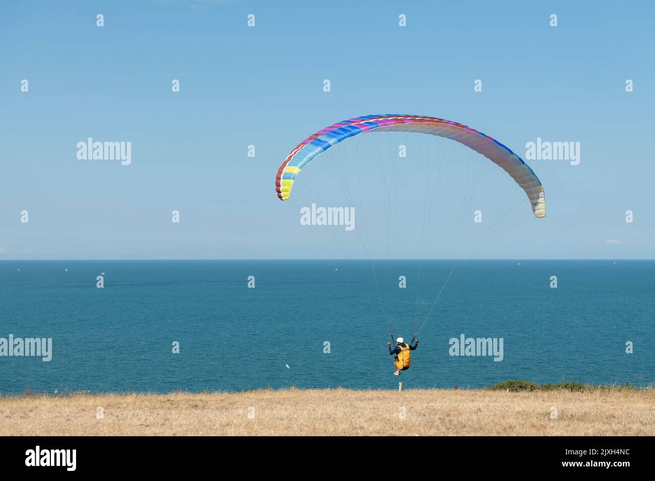Paragliding flight over the beach on the cliffs Stock Photo - Alamy