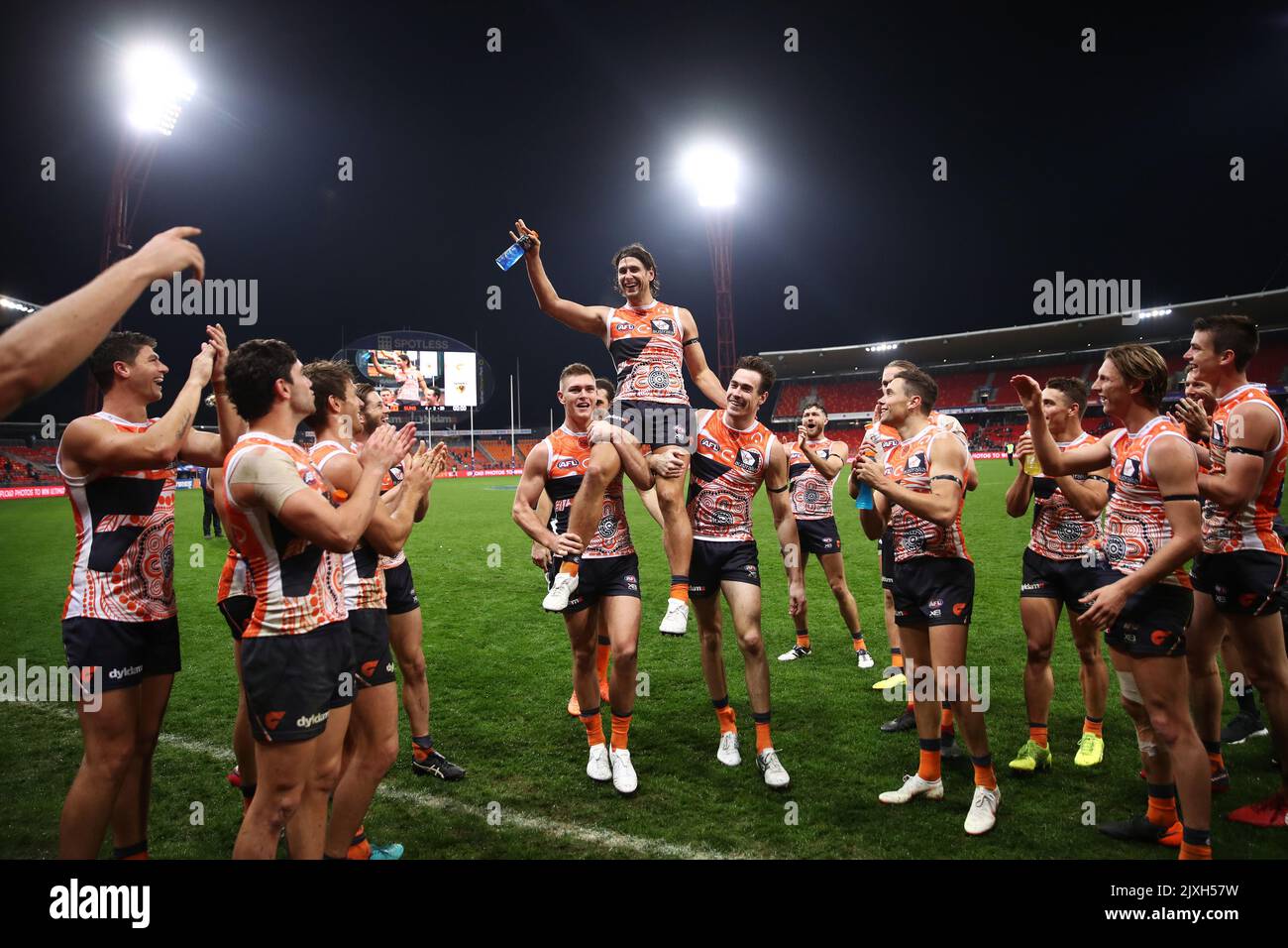 Ryan Griffen of the Giants is carried from the field by his team mates ...
