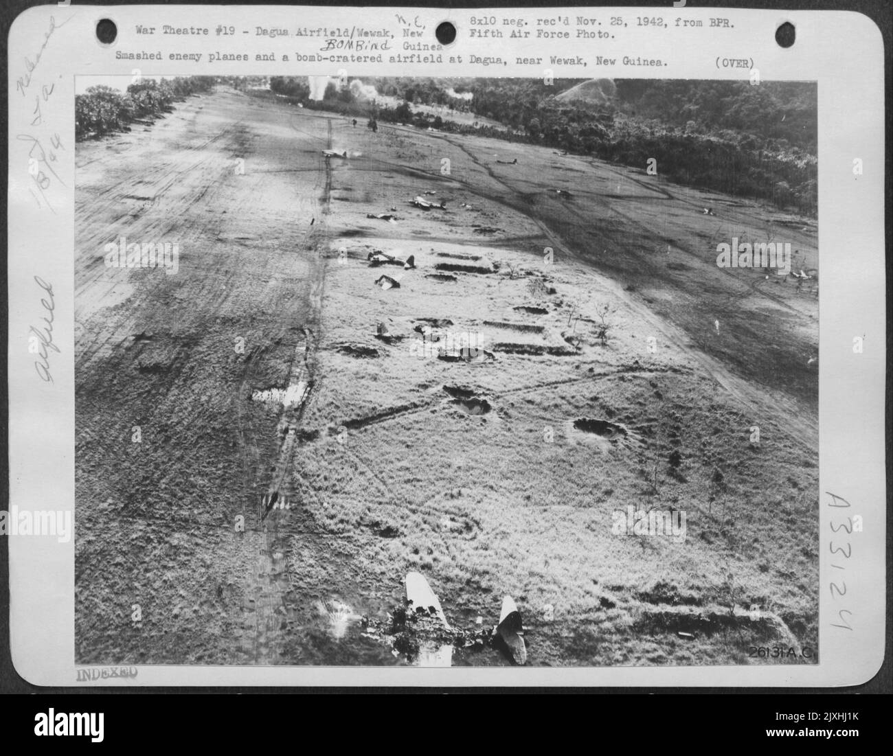 Smashed enemy planes and a bomb-cratered airfield at Dagua, near Wewak ...