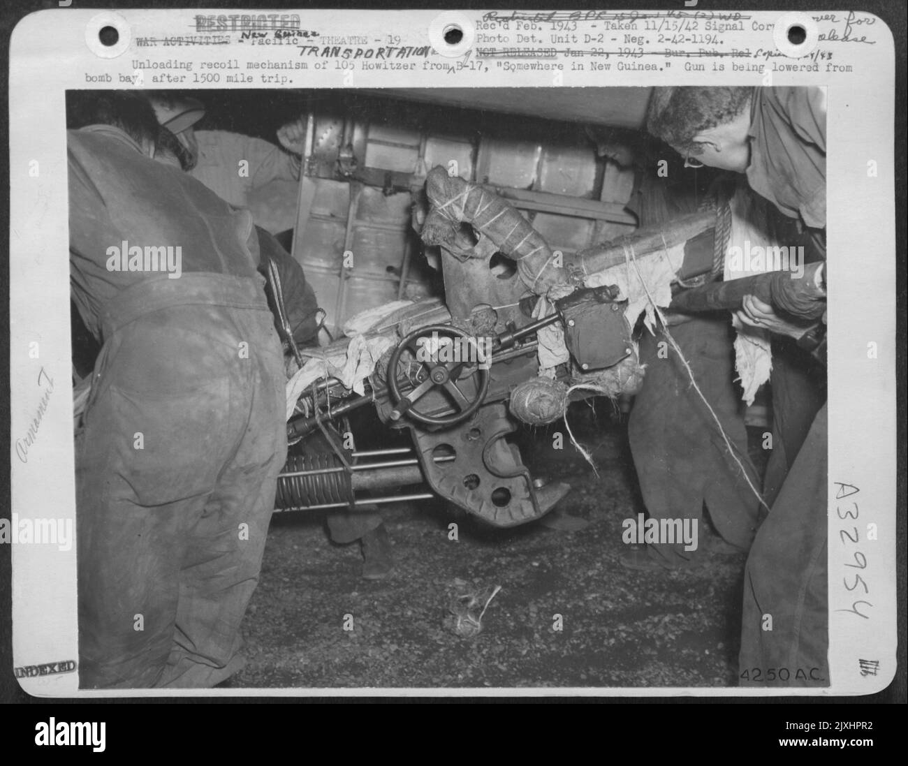 Unloading recoil mechanism of 105 Howitzer from B-17, "Somewhere in New ...
