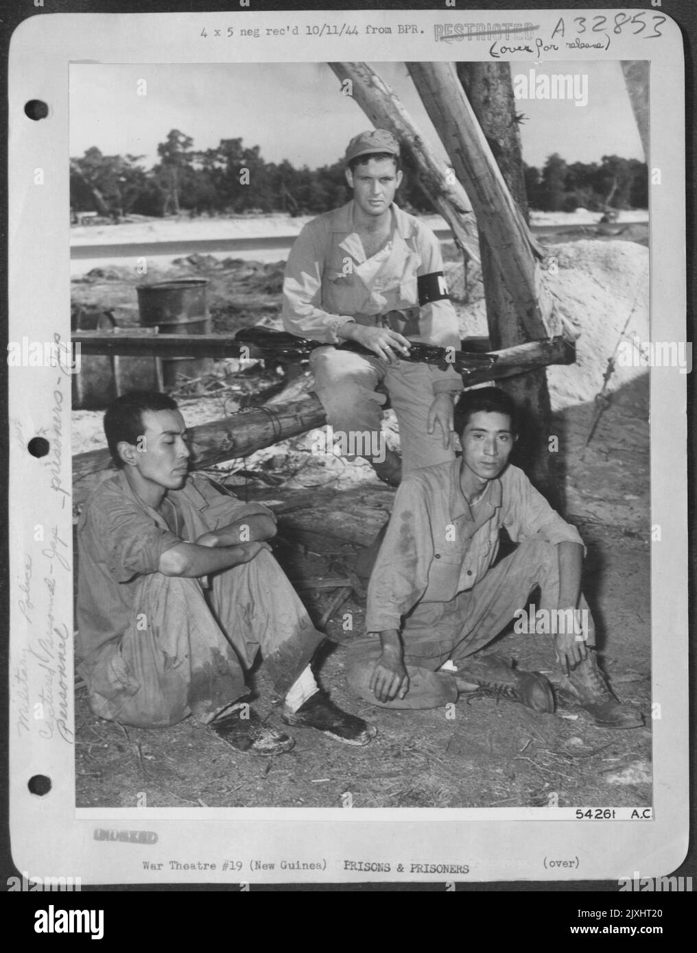 Pvt. William Fleeman, Los Angeles, California, guards two prisoners of ...