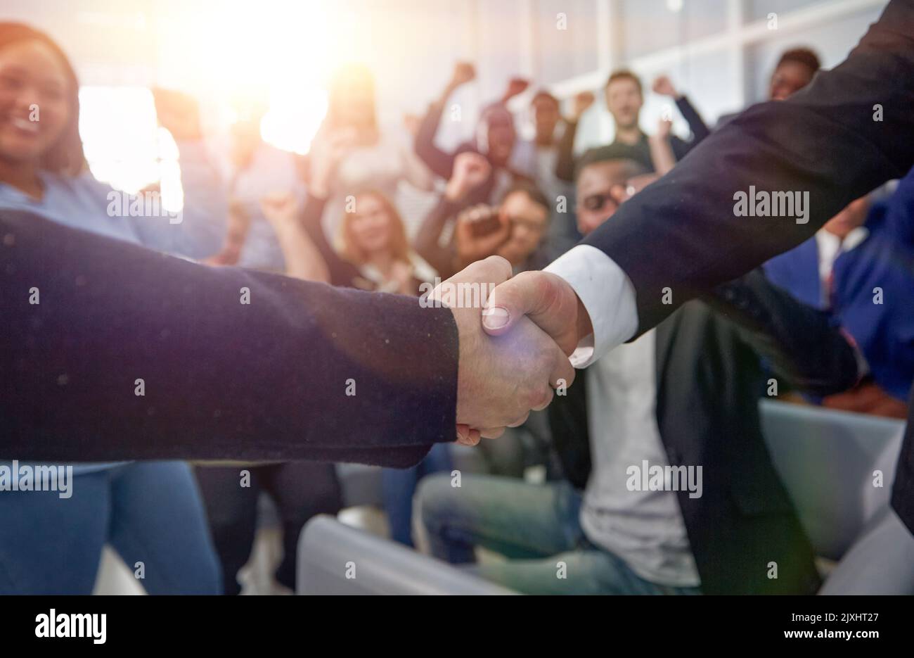 Welcoming business man giving a handshake and smiling Stock Photo - Alamy