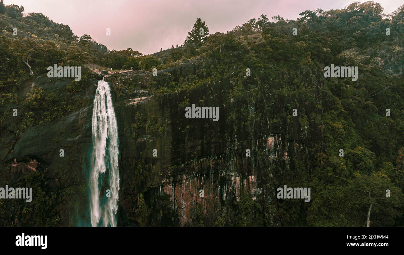 Natural Landscape with a huge waterfall from the mountains, green hills ...