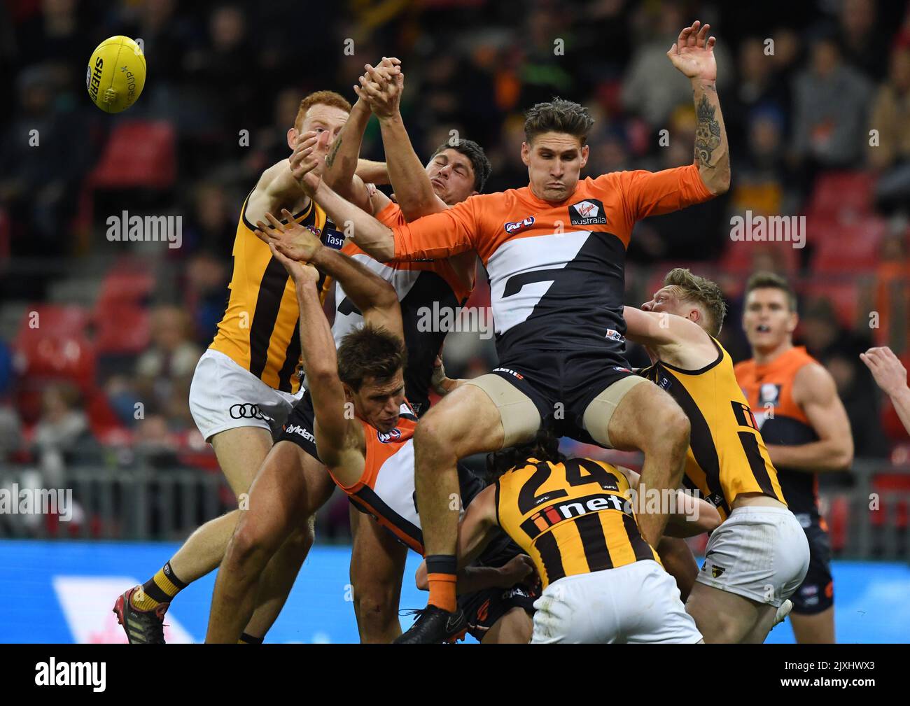 Rory Lobb of the Giants (centre) jumps onto the Hawks players as he ...