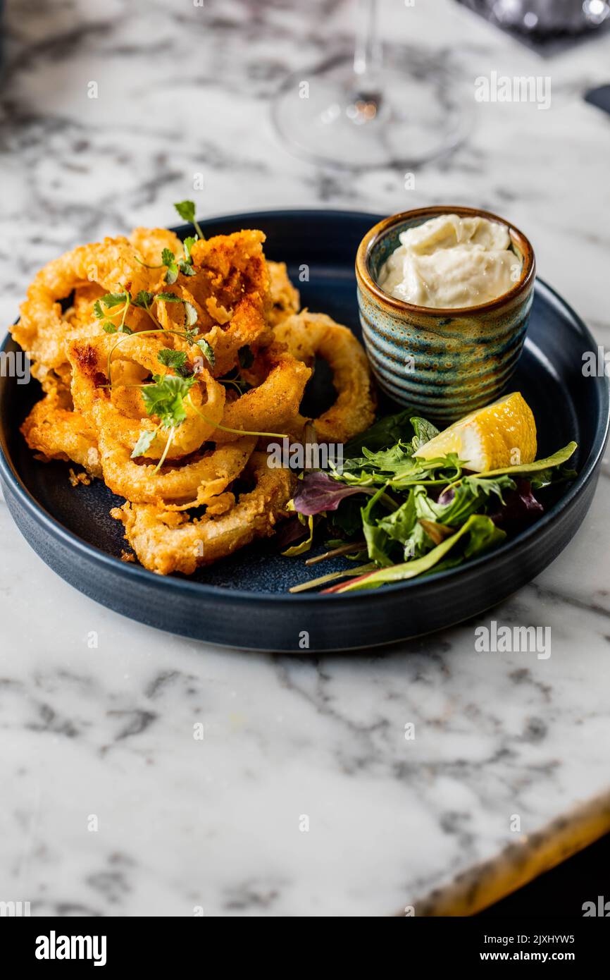 A vertical shot of crispy onion rings with a dip Stock Photo - Alamy