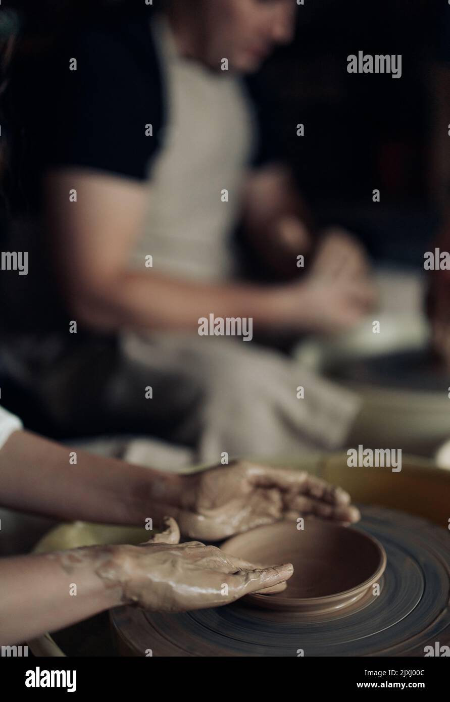 Hands of potter sculpt handmade earthenware on spinning pottery wheel ...