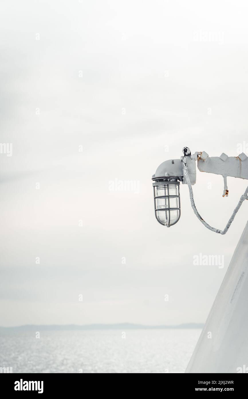 A ship lighting on white ferry boat in the ocean with white clouds in ...