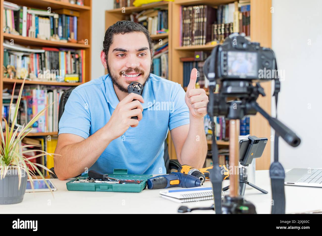 A young Caucasian man making a vlog and interacting with viewers ...