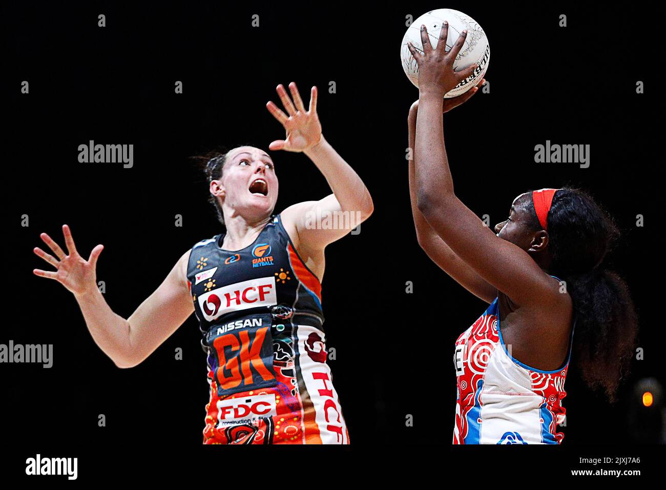 Sam Wallace of the Swifts (right) shoots as Sam Poolman of the Giants ...