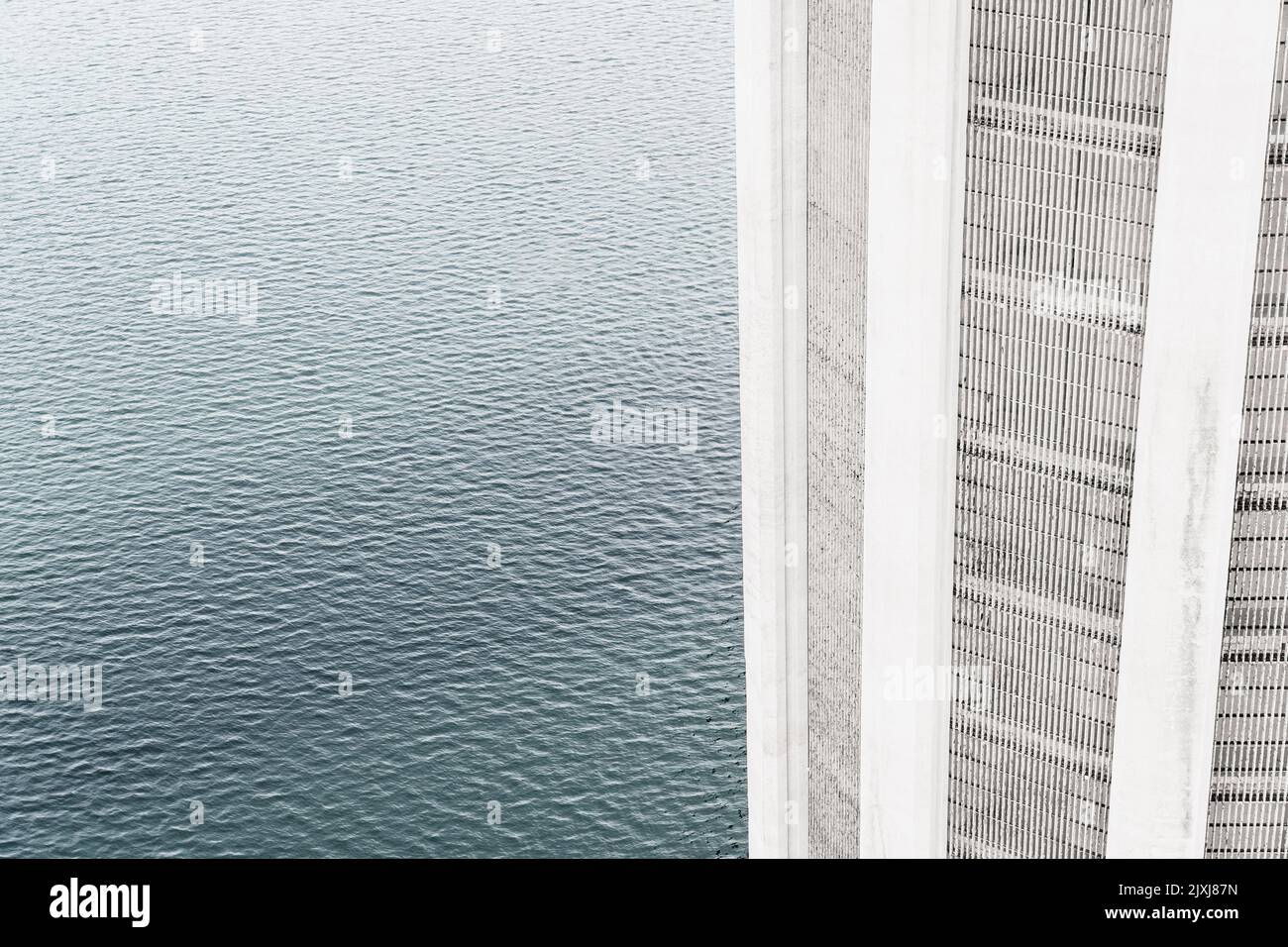 A white building and smooth pale blue water surface Stock Photo - Alamy