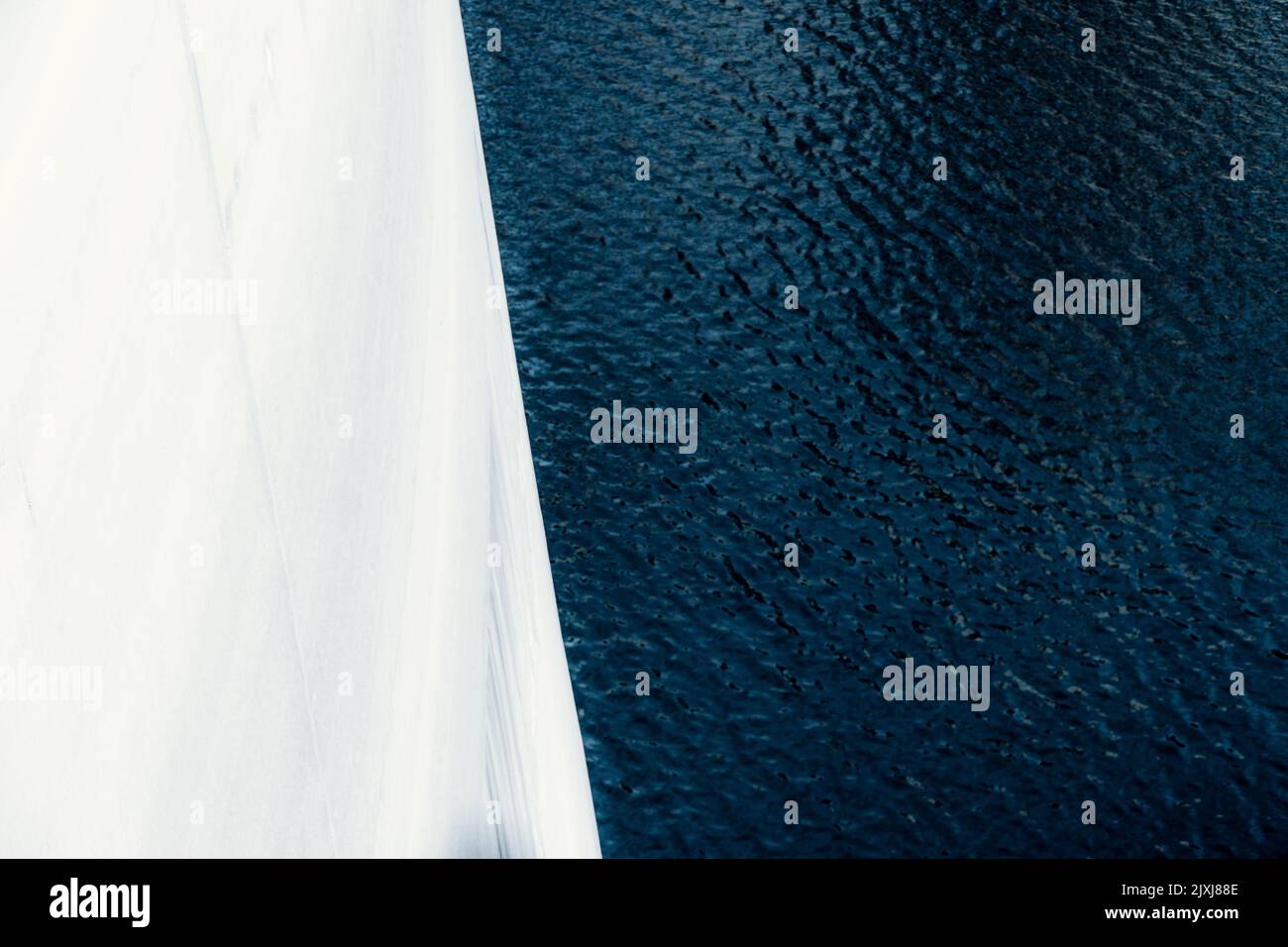 A white wall and smooth blue water surface Stock Photo - Alamy