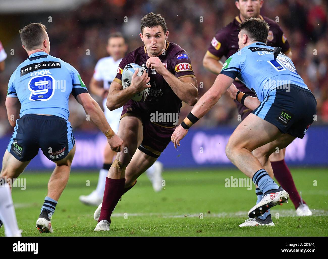 Corey Oates (centre) of the Maroons is tackled by Damien Cook (left ...