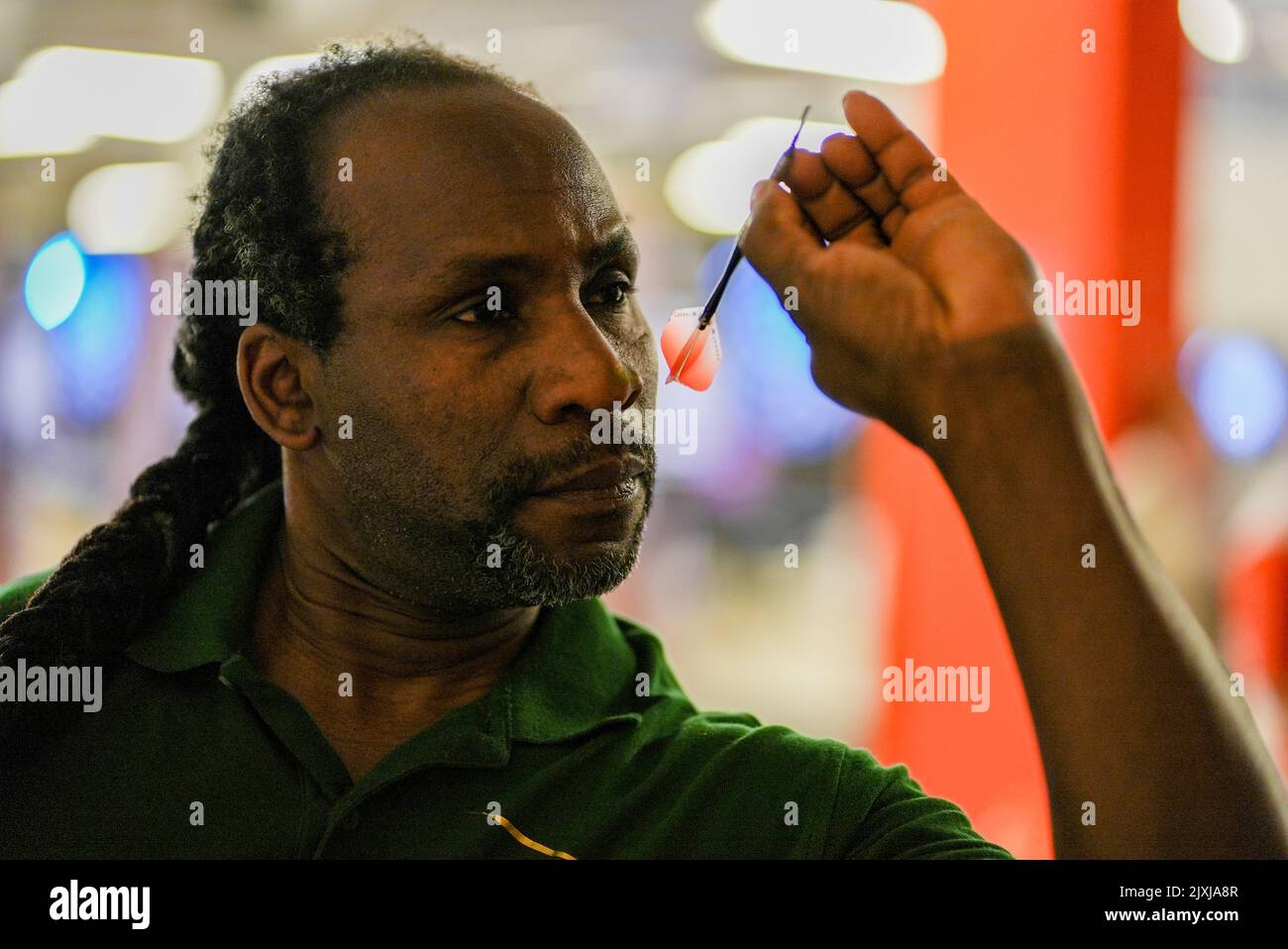 Close up of a black darts player throwing darts Stock Photo - Alamy