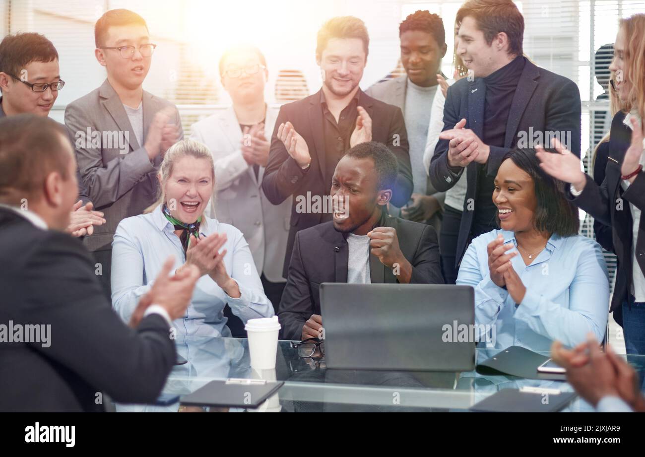 Happy multi-ethnic business people around a conference table Stock Photo - Alamy