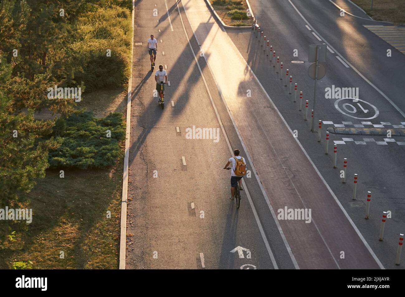 Top aerial view of cyclist and two mans are riding on kick scooters on ...