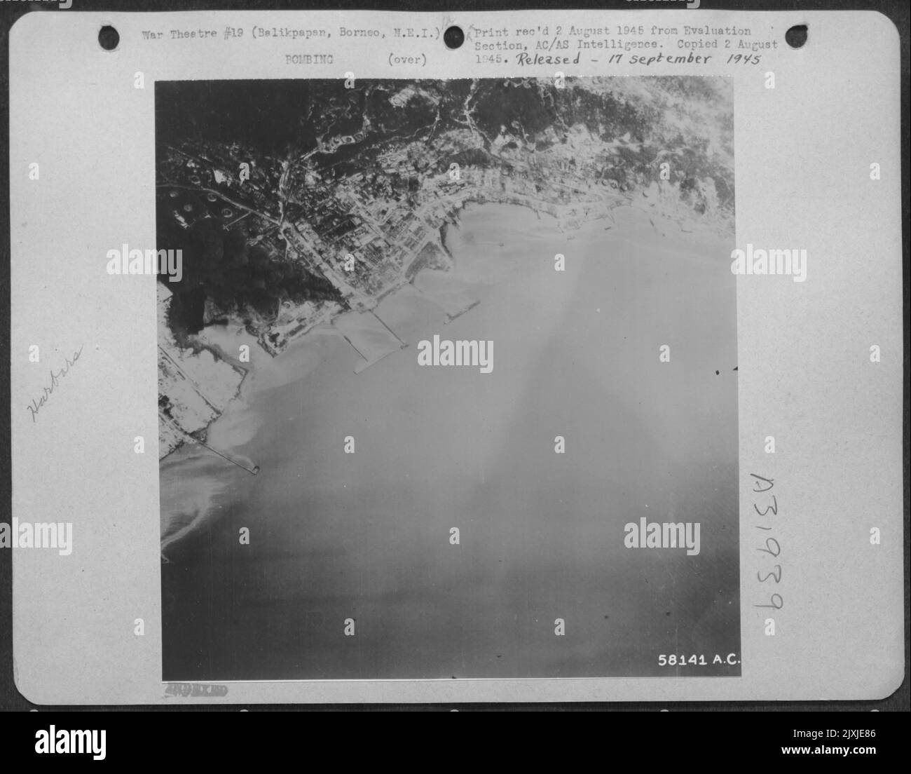 Smoke pours from harbor installations at Balikpapan, Borneo, N.E.I ...