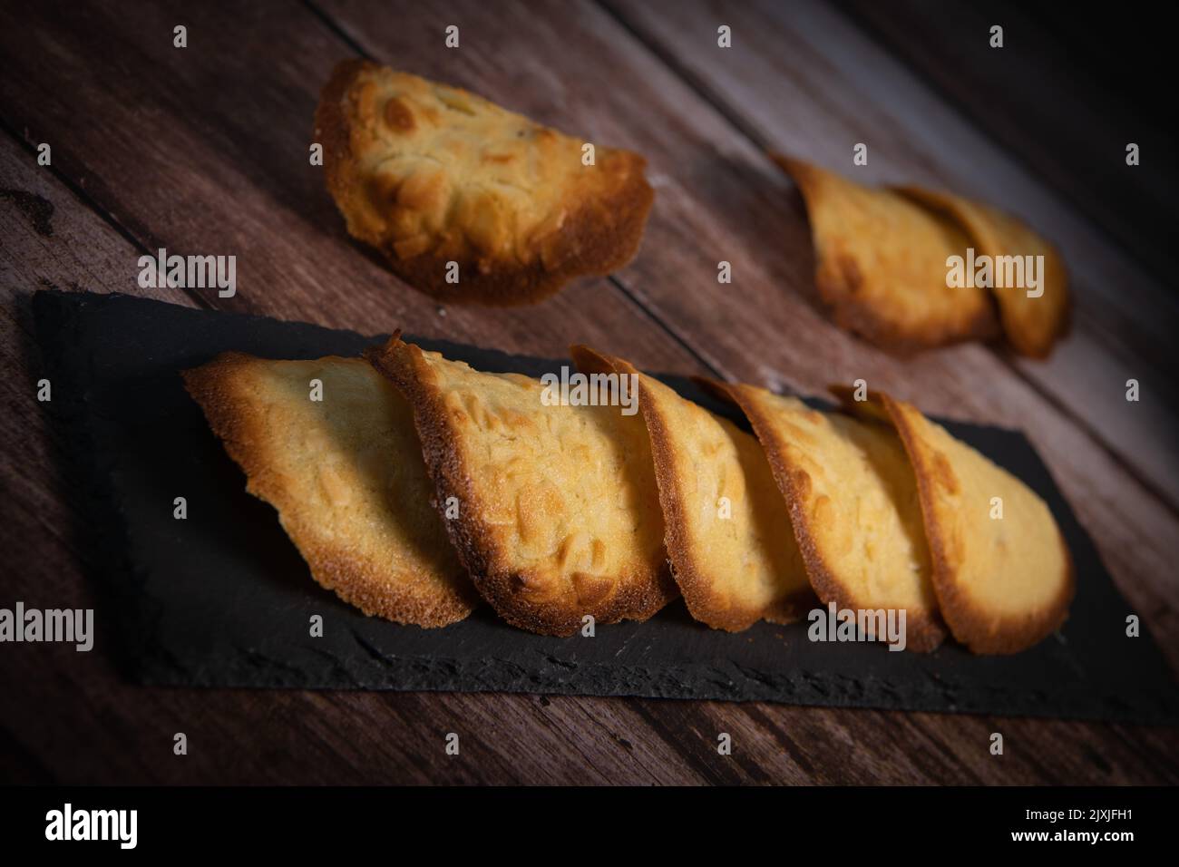 French delicacy pastry tuile with almond on wood background Stock Photo ...