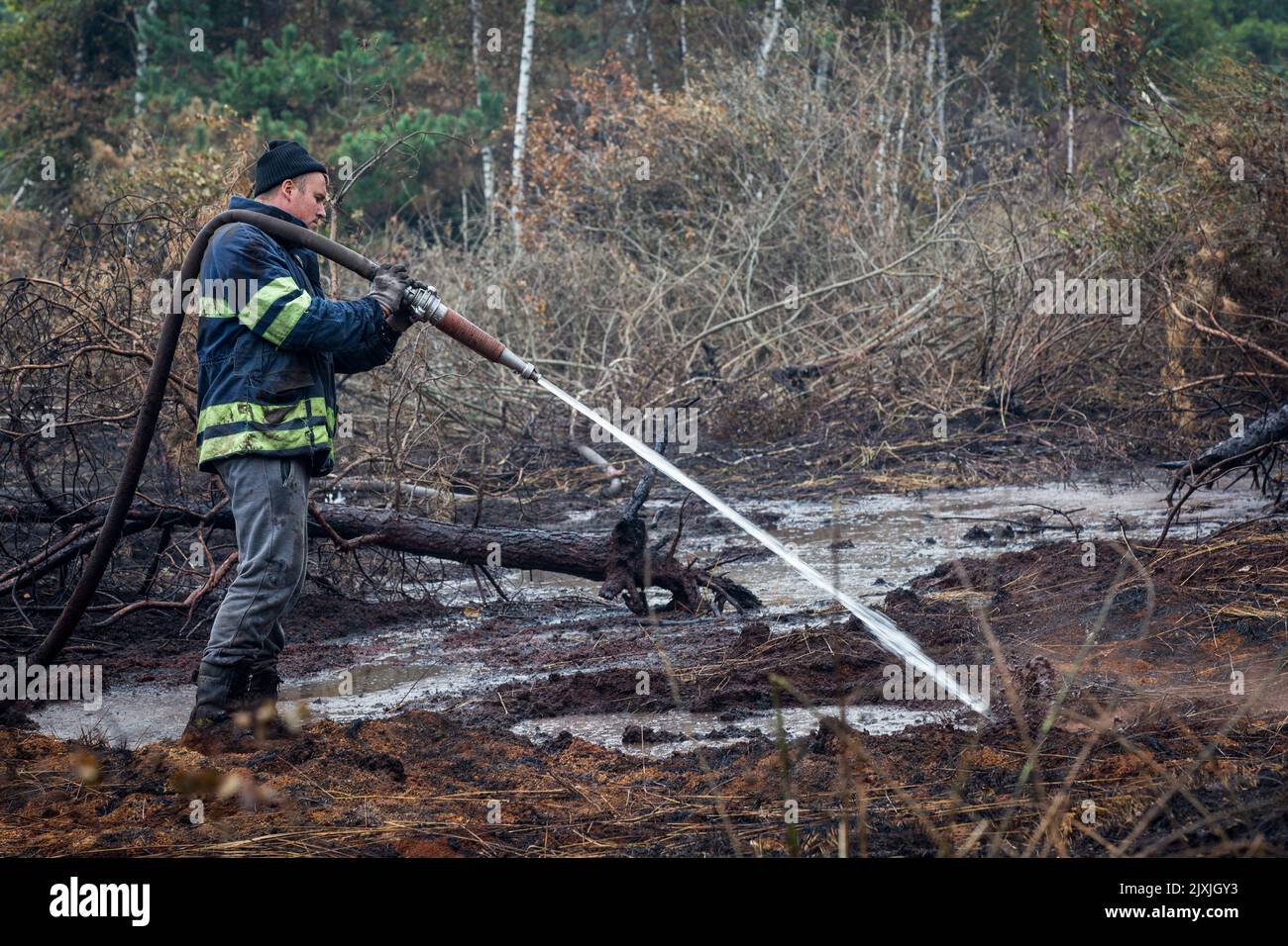 A firefighter puts out a fire in a peat bog in the village of Sosnivka ...