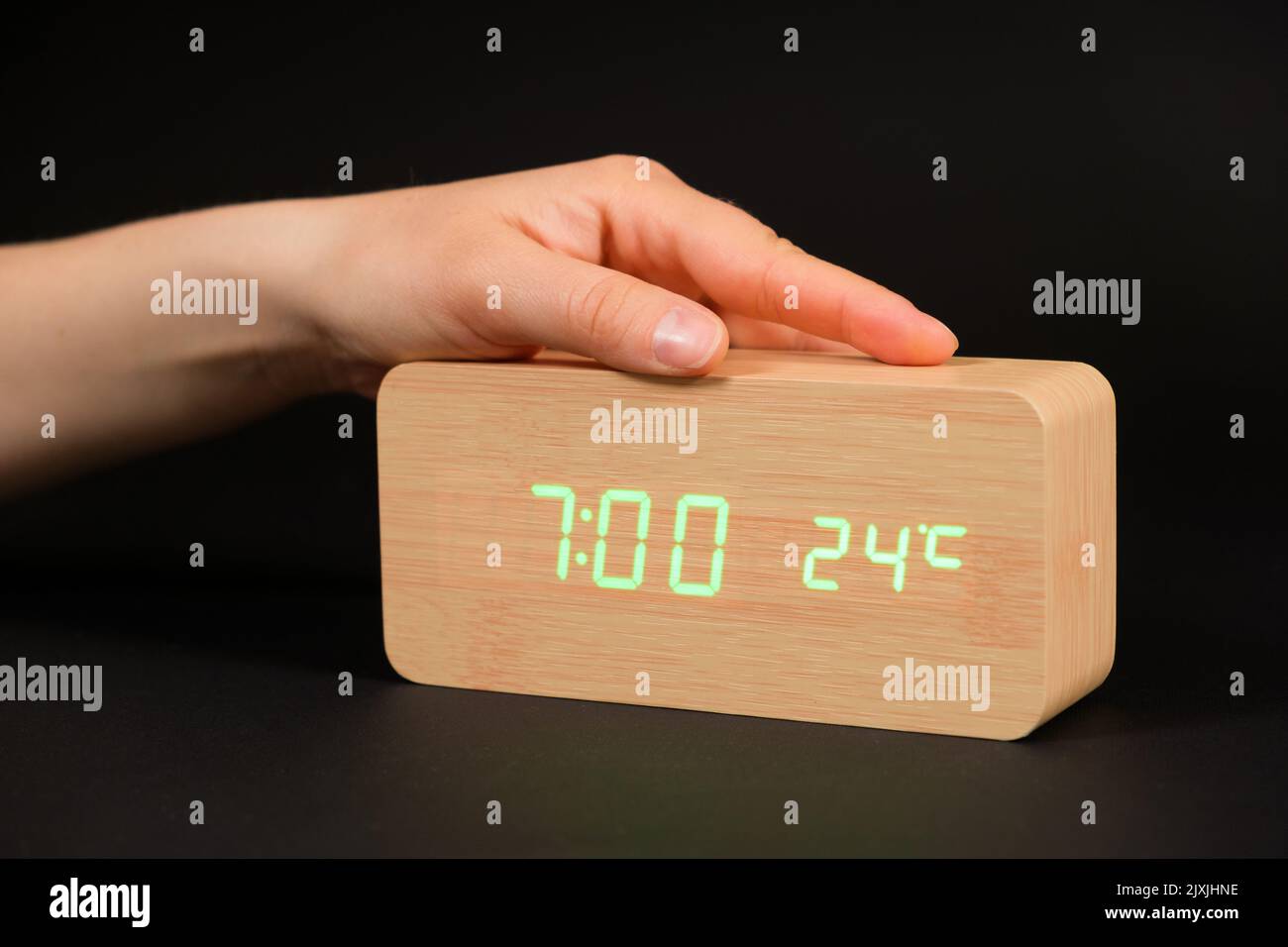 A digital clock showing a time of seven o'clock in the morning and a ...