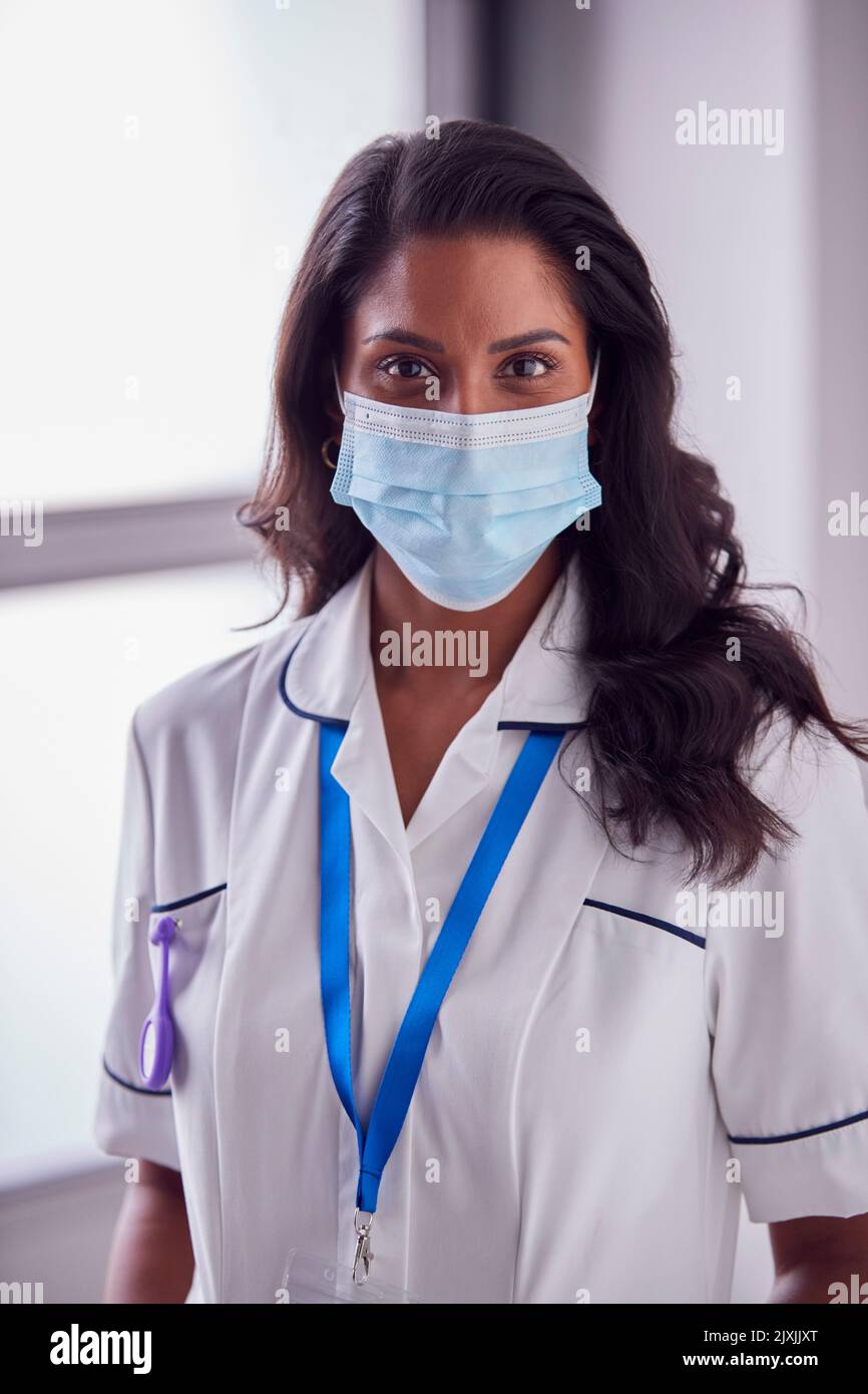 Portrait Of Female Mature Nurse In Uniform Wearing Face Mask In ...
