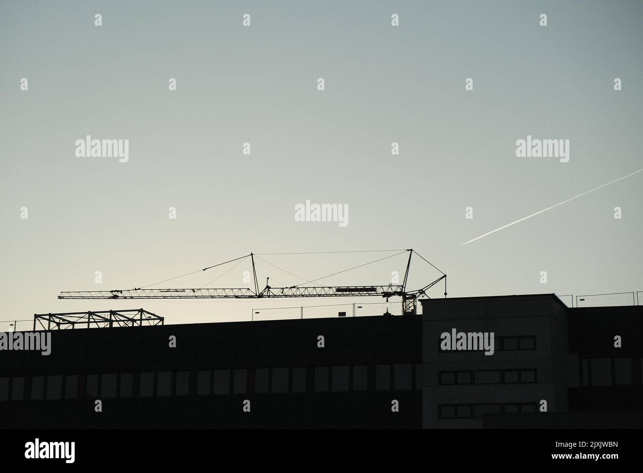 A long industrial crane behind a building in clear sky background Stock ...