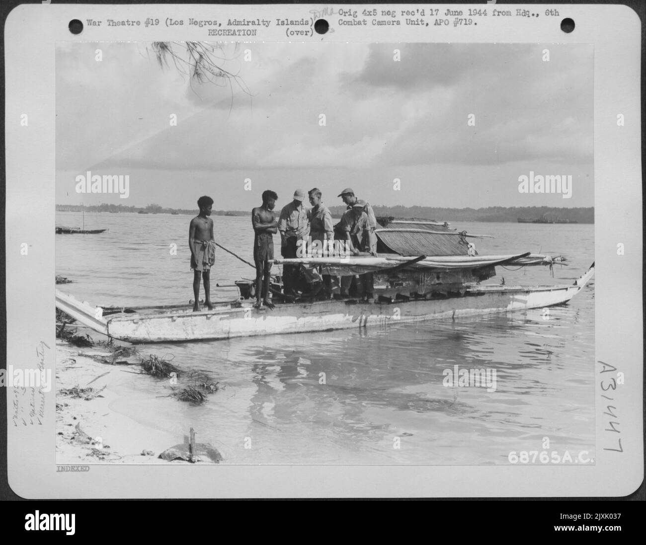 Men from the 72nd Bomb Squadron, 5th Bomb Group, look over a native ...