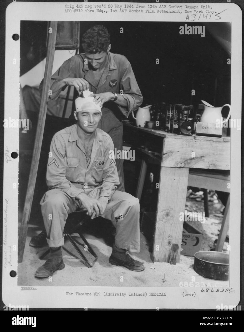An attendant at a First Aid Station in the Admiralty Islands bandages ...
