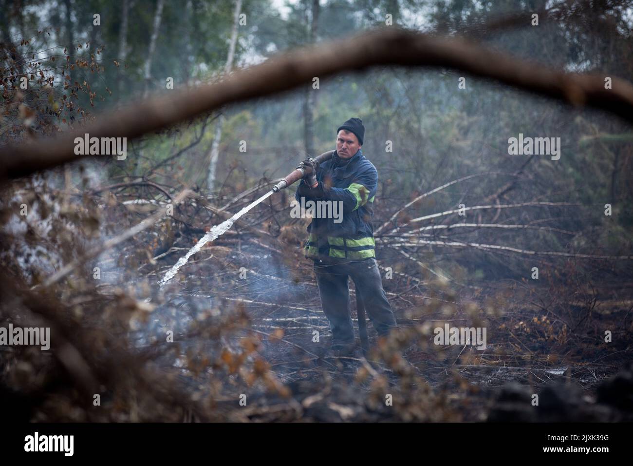 A firefighter puts out a fire in a peat bog in the village of Sosnivka ...
