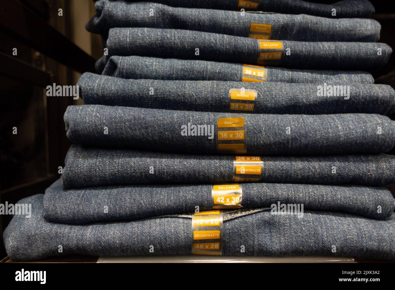 Pilles of Denim jeans on display in a clothing store Stock Photo - Alamy