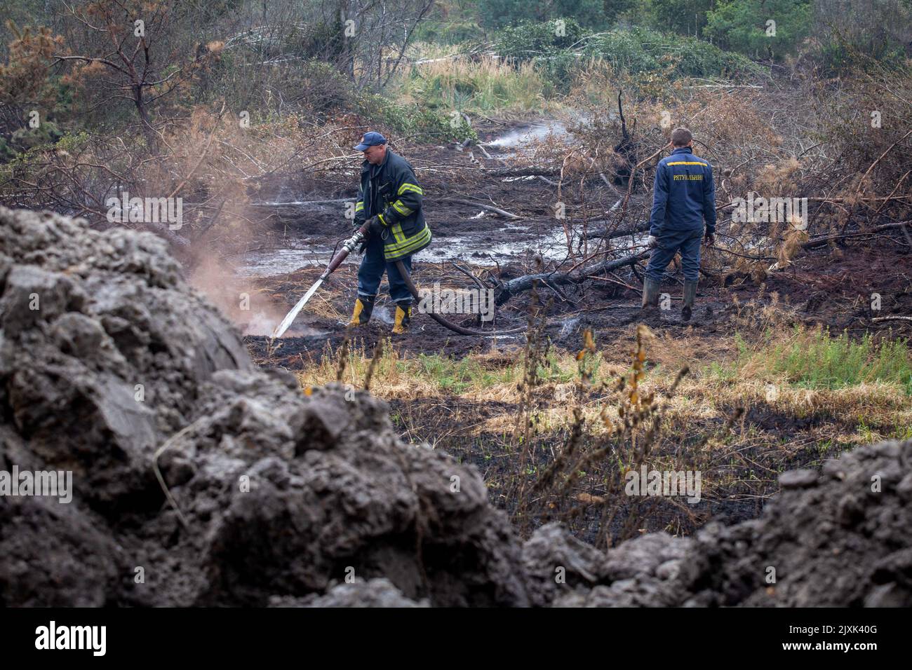 Firefighters put out a fire in a peat bog in the village of Sosnivka in ...