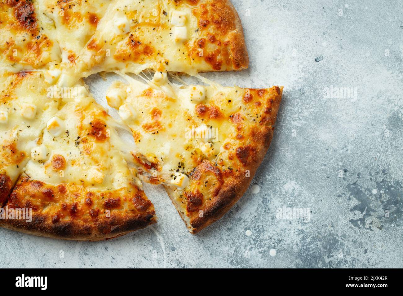Italian pizza four cheeses with stretching cheese and basil on a light ...