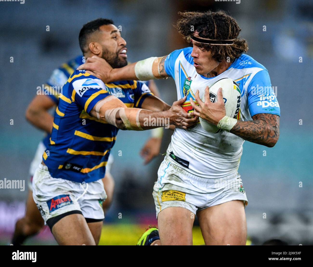 Kevin Proctor (left) of the Titans runs with the ball against the Eels ...