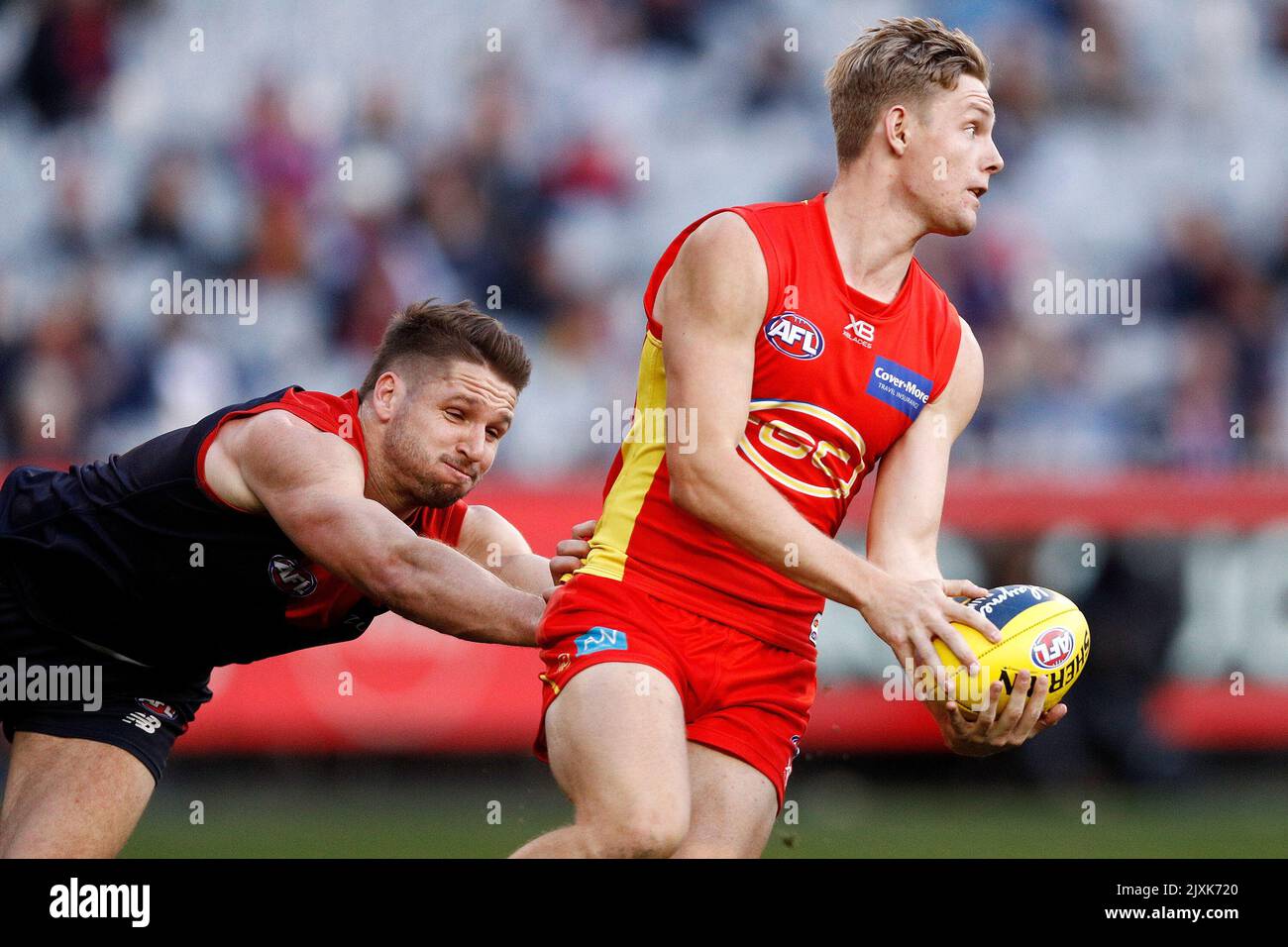 Max Spencer of the Suns runs with the ball under pressure from Jesse ...