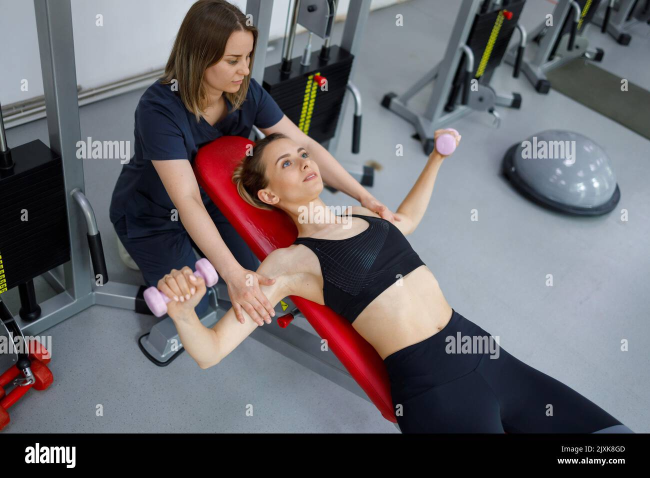 Rehabilitation specialist instructing female patient exercising with ...