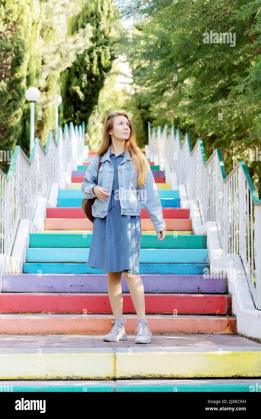 Woman on multi-colored steps. Concrete colored staircase. Blonde woman ...