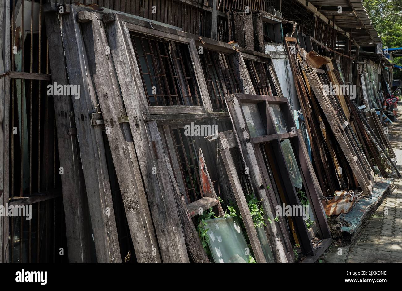 Old frames and shutters with glass from dismantled are stacked against ...