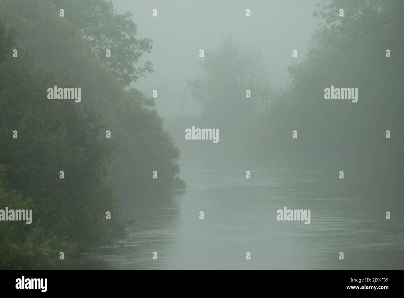 Sombre autumn landscape scene with river, mist, fog, grey and dark ...
