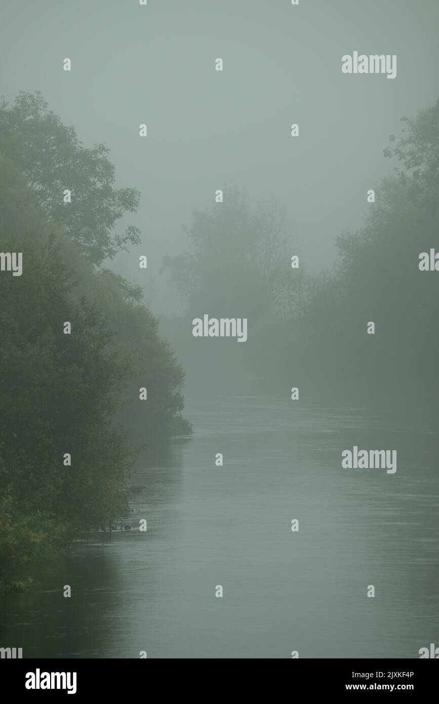 Sombre autumn landscape scene with river, mist, fog, grey and dark ...