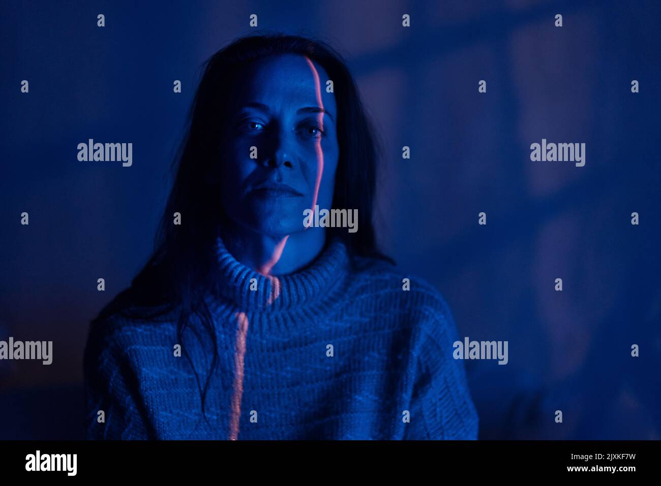 Woman sitting in dark room hi-res stock photography and images - Alamy