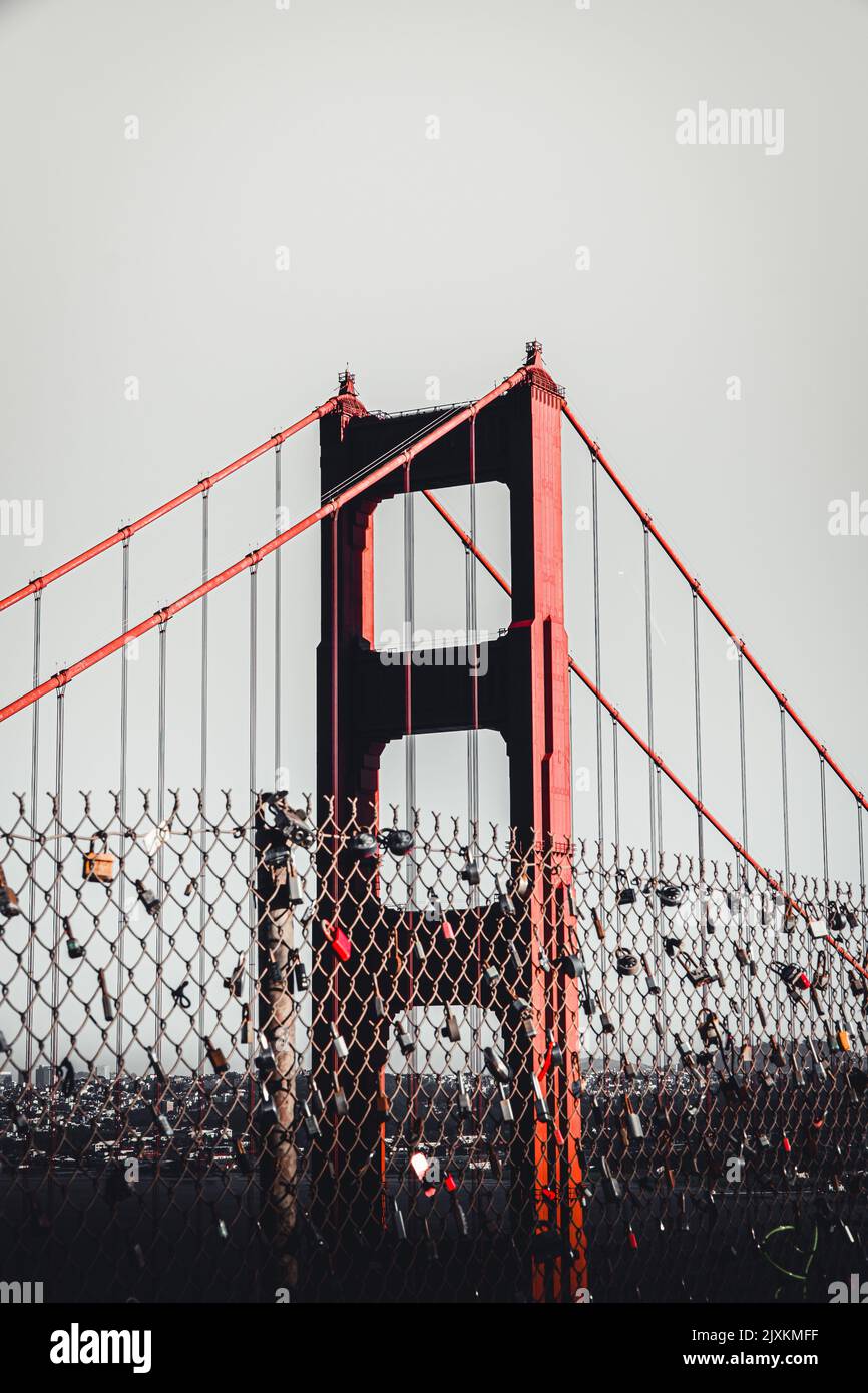 A grid fence with padlocks on the background of the Golden Gate Bridge ...