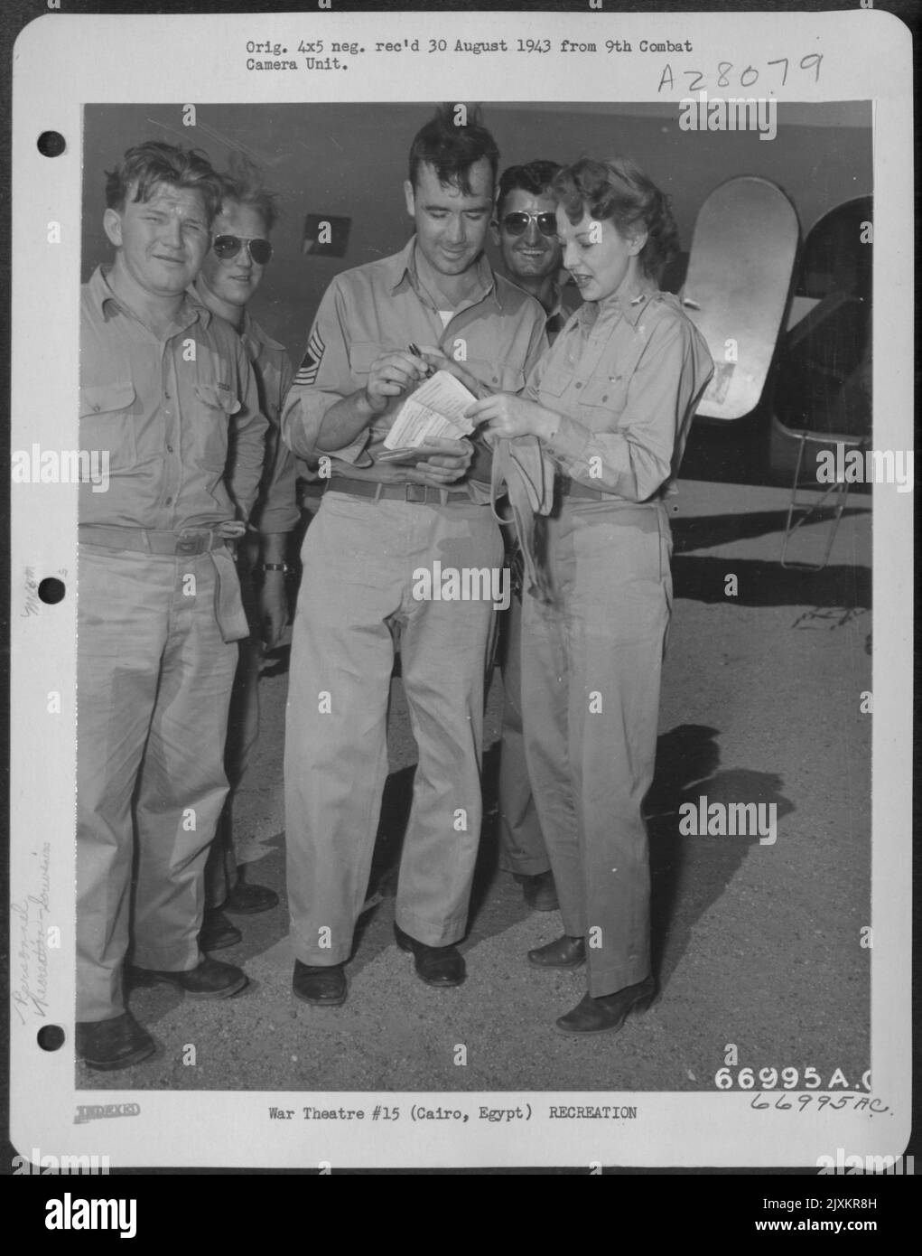 Anna Lee, a member of the Jack Benny show troupe, autographs a slip of ...