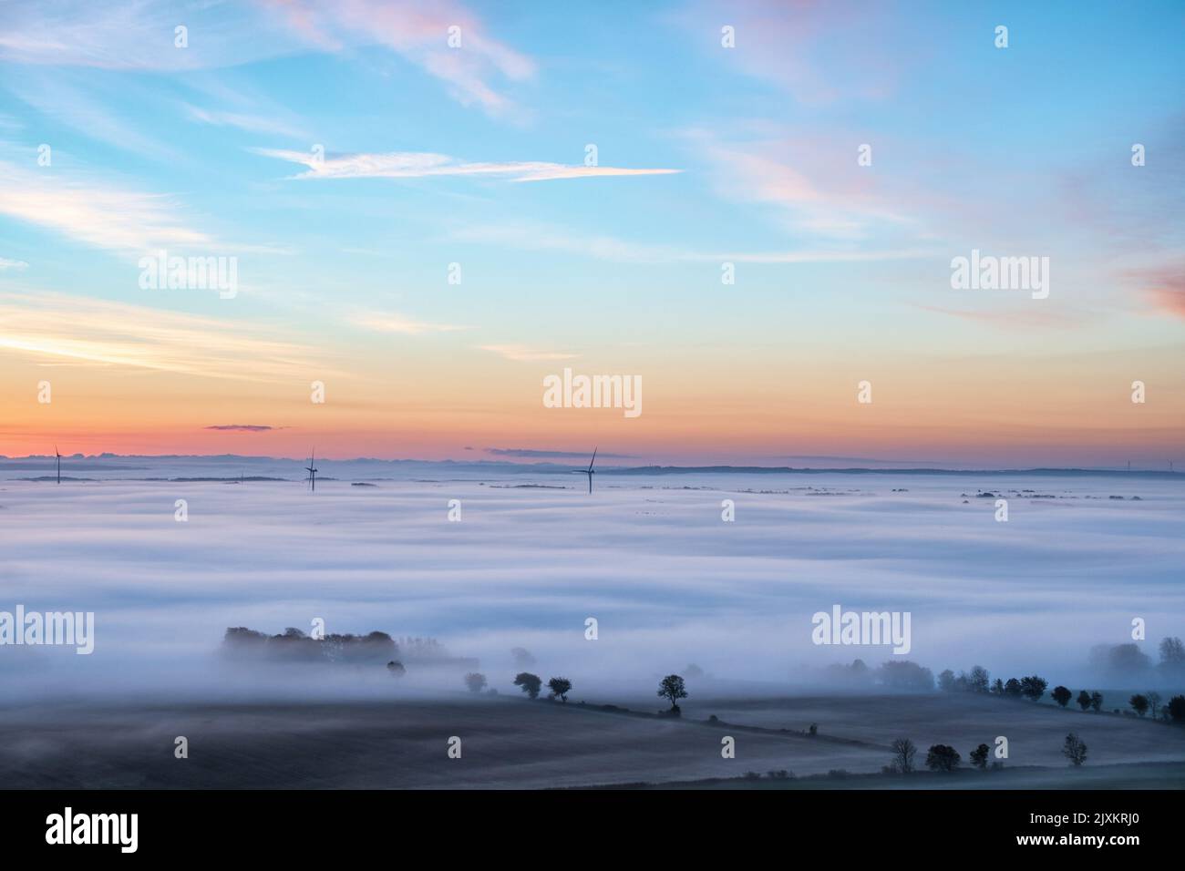 Awesome sunrise with fog in the cultivated landscape Stock Photo - Alamy